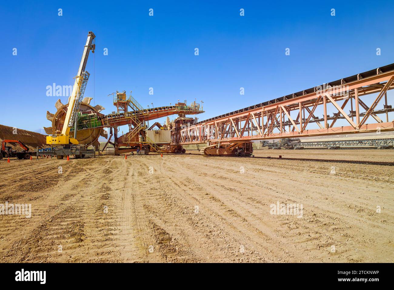 A giant rotary shovel with a portable conveyor belt machinery at a ...