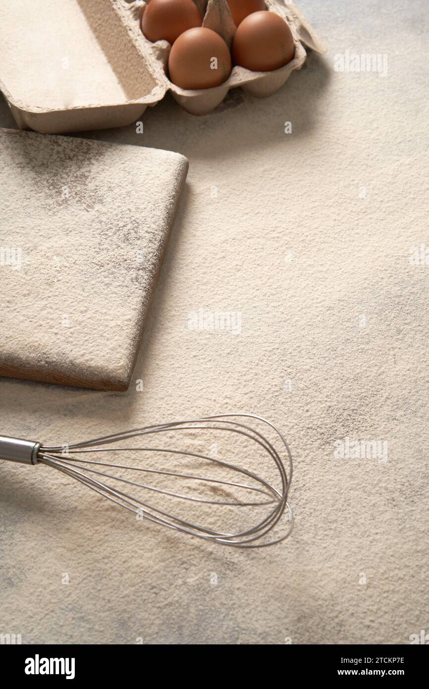 Baking background with flour, eggs and egg whisk. Vertical photo Stock ...