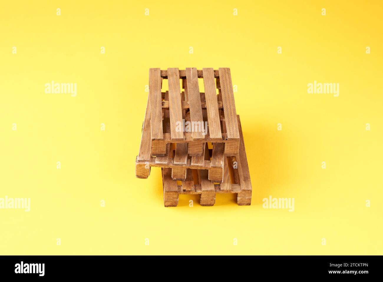 wooden miniature pallets on a yellow background Stock Photo - Alamy