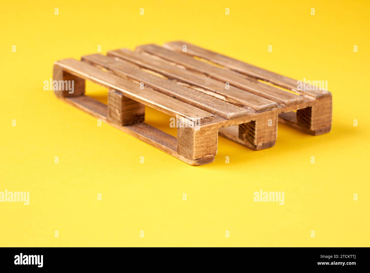 wooden miniature pallets on a yellow background Stock Photo - Alamy
