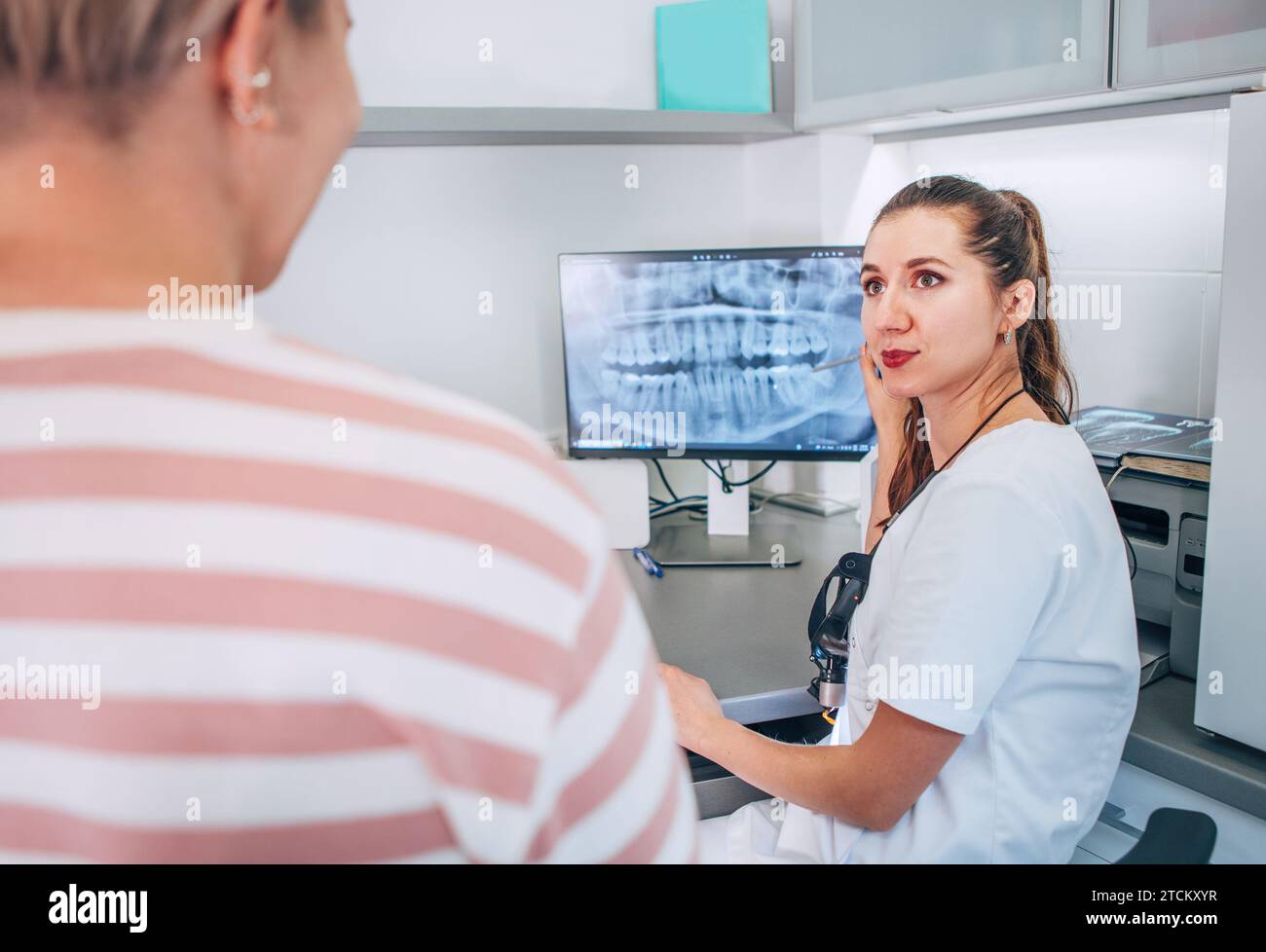 Dentist female doctor in uniform showing intraoral 3D dental X-rays ...