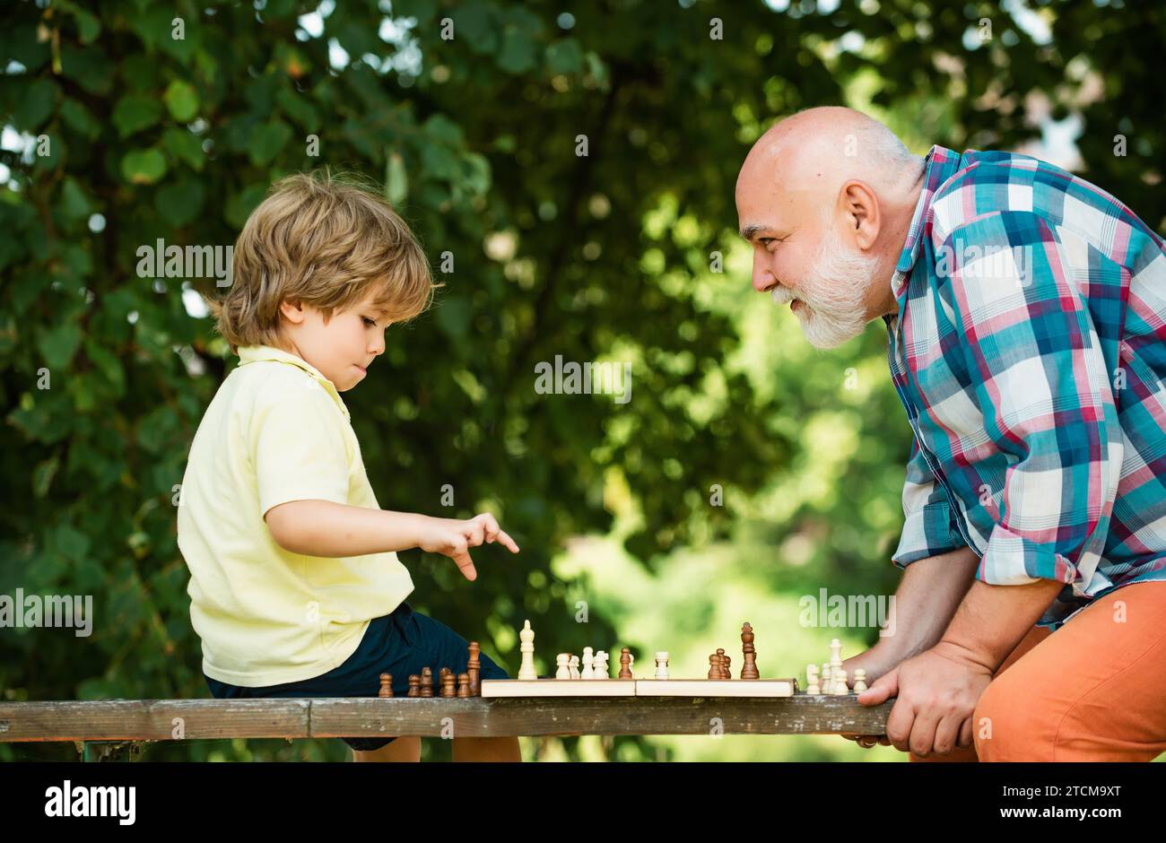 Handsome grandpa and grandson are playing chess while spending time ...