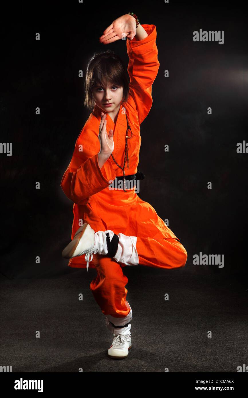 Wushu Girl dressed in orange make exercise of Shaolin taolu Stock Photo ...