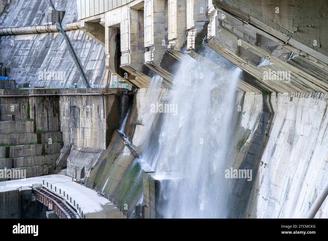 Hydroelectric power plant. Water stream flows from concrete dam gates ...