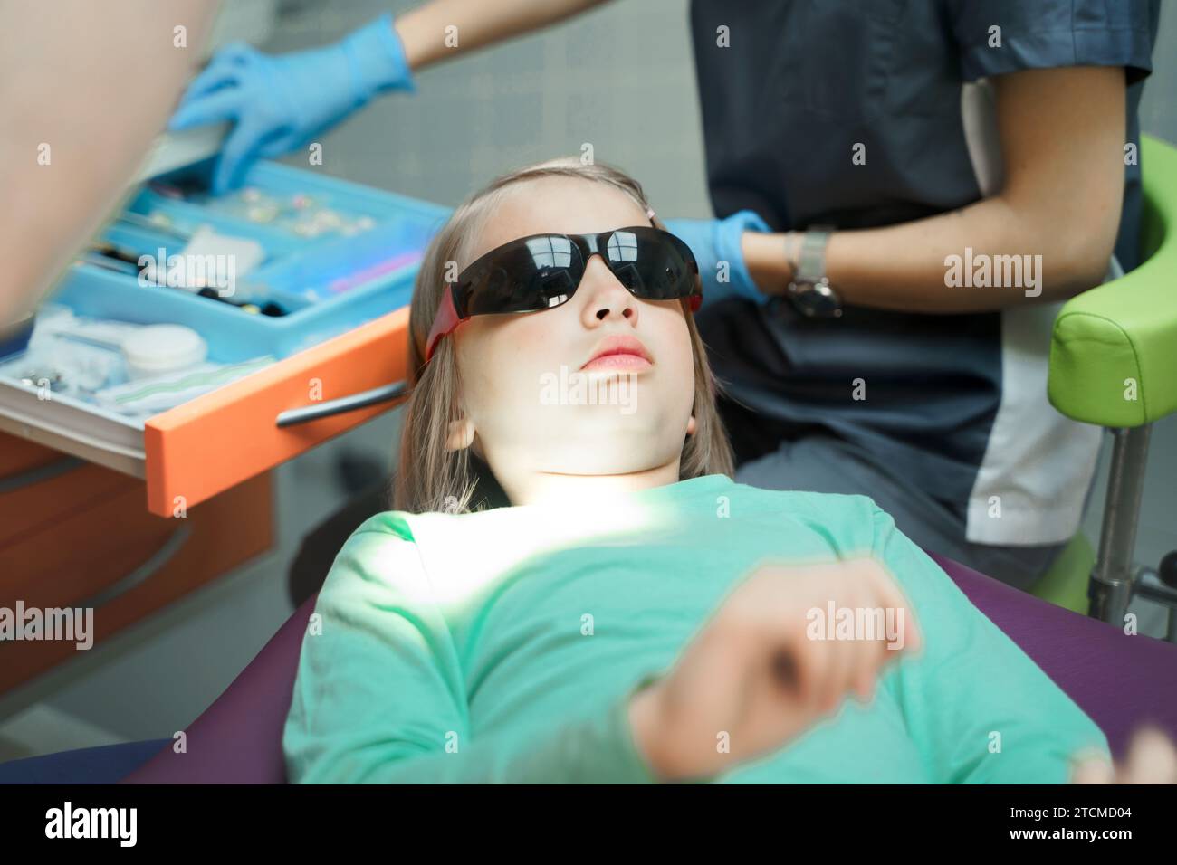 Little scared girl sitting in chair in dentist doctor office ...