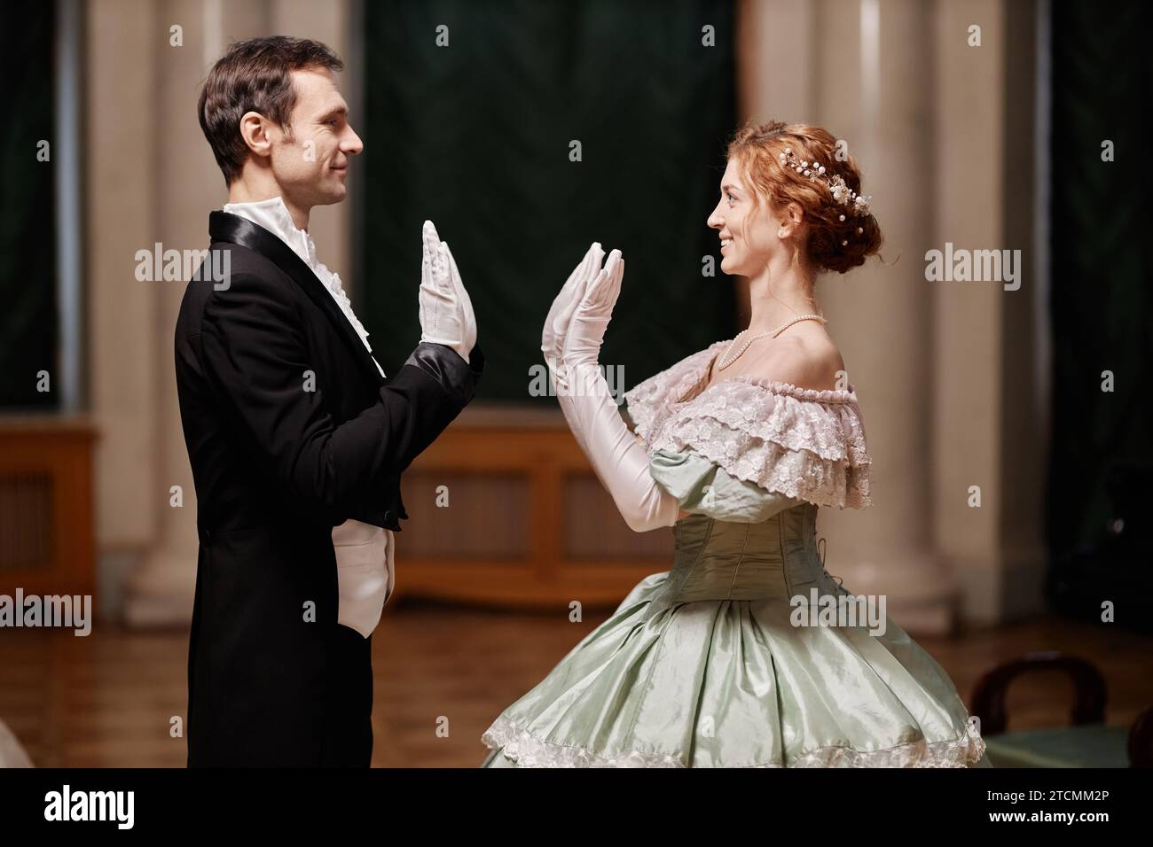 Side view portrait of young lord and lady dancing together in palace ...