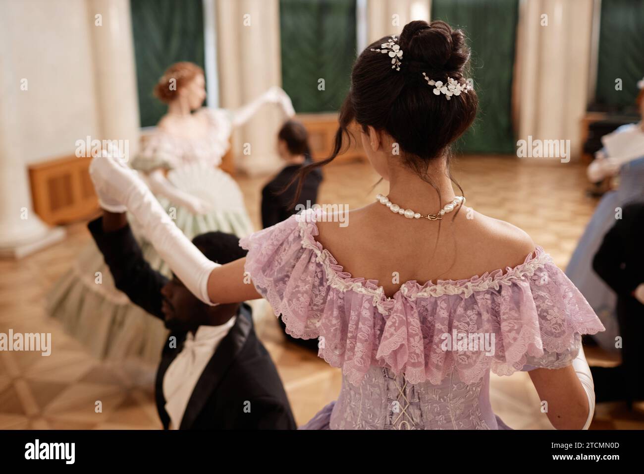 Back view of beautiful lady wearing ballgown dancing with gentleman ...