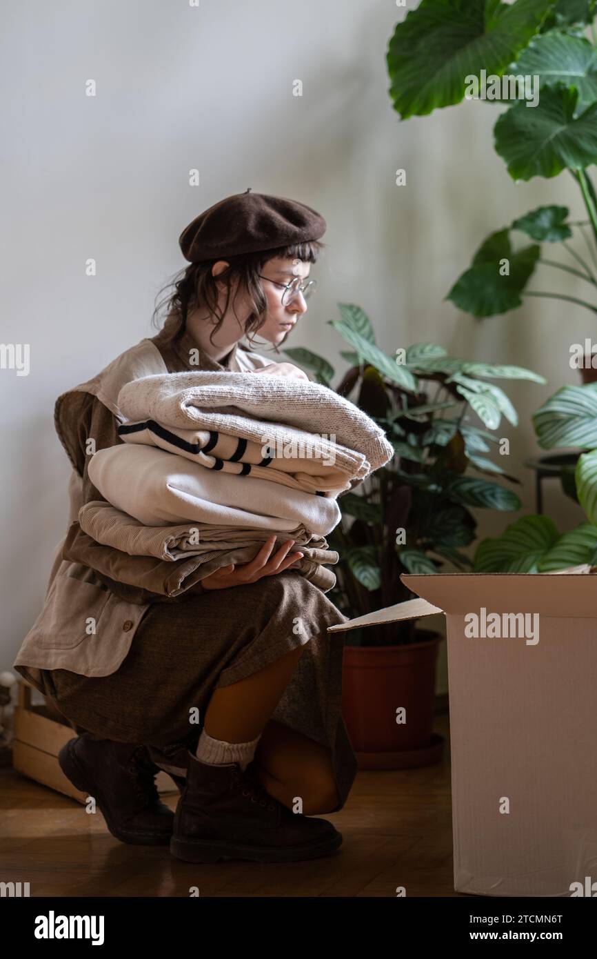 Girl social worker collecting things clothes for recycling donations ...