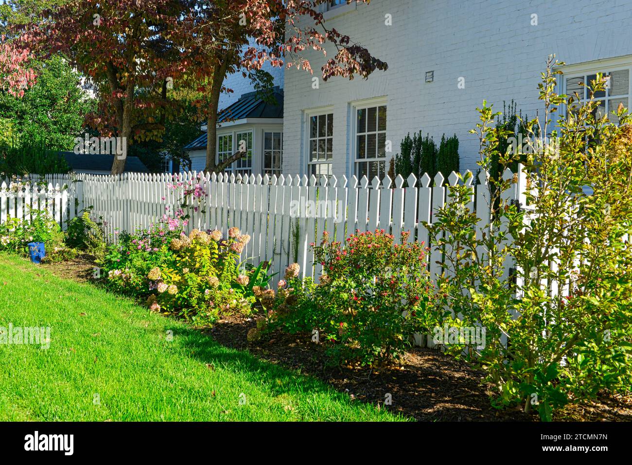 Traditional white-painted picket fence around a house in the historic ...