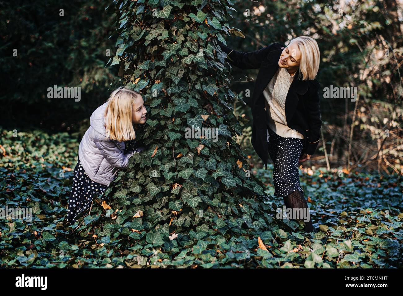 Mother and Daughter Playing Hide and Seek in Park. A joyful mother and ...