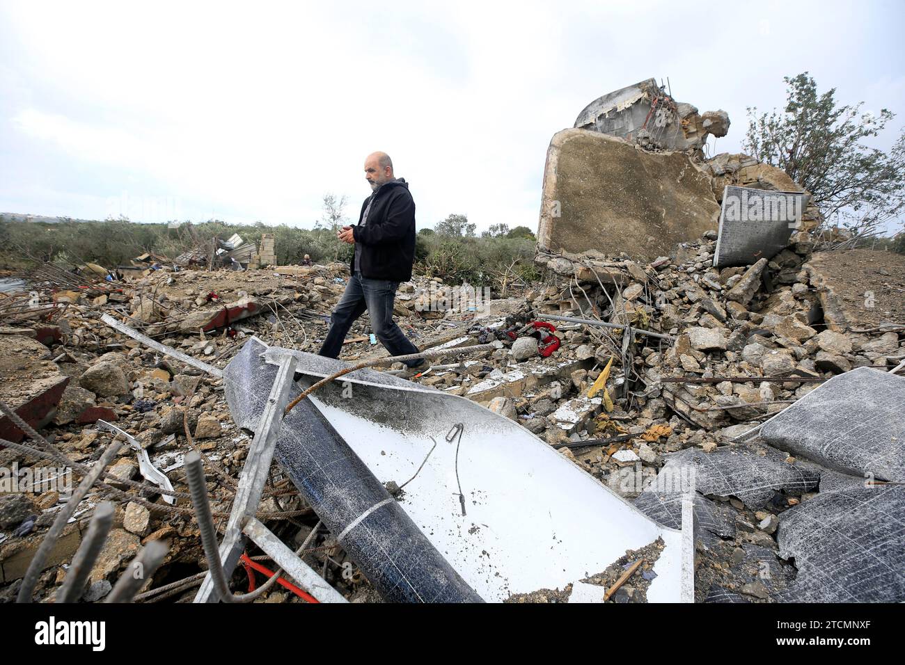 Tayr Harfa, Lebanon. 13th Dec, 2023. A man walks among the rubble of a ...