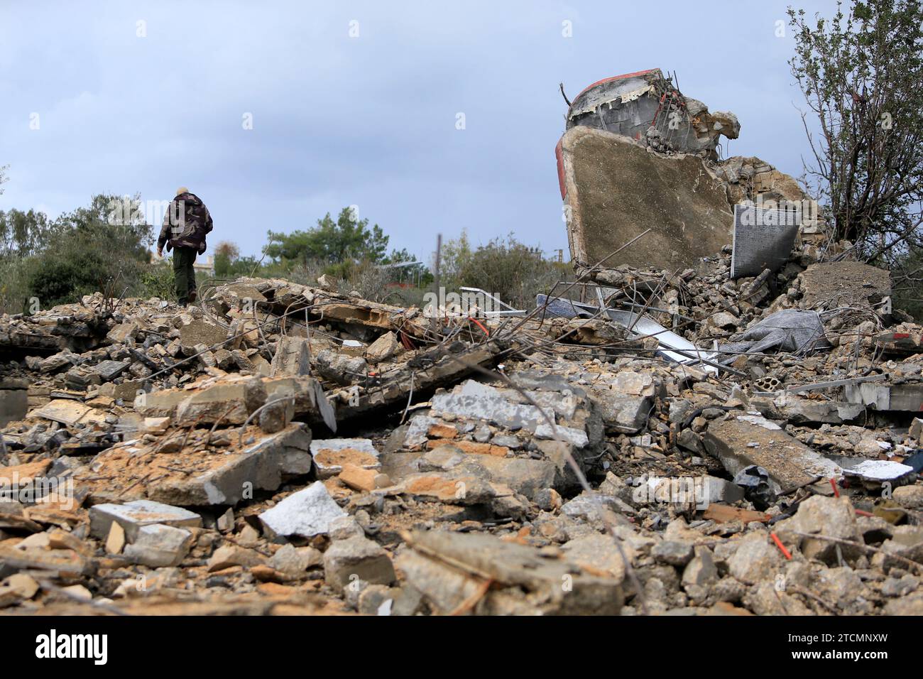 Tayr Harfa, Lebanon. 13th Dec, 2023. A man is seen among the rubble of ...