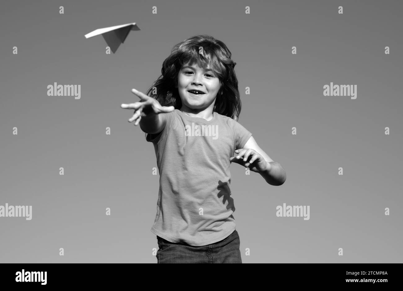Boy child holding a paper airplane outdoor. Happy child playing with ...