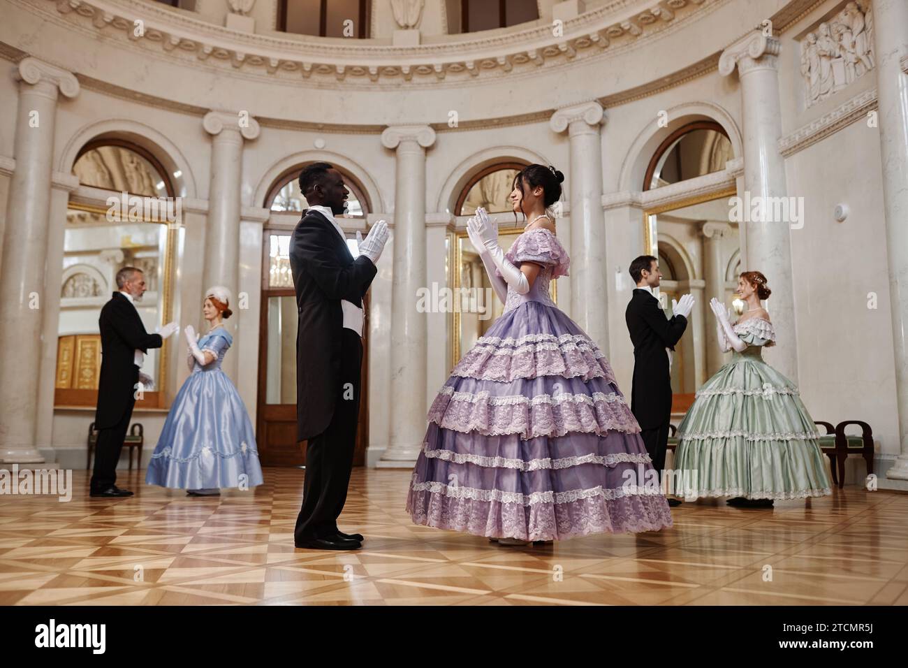Full length wide angle of palace ballroom with ladies and gentlemen ...