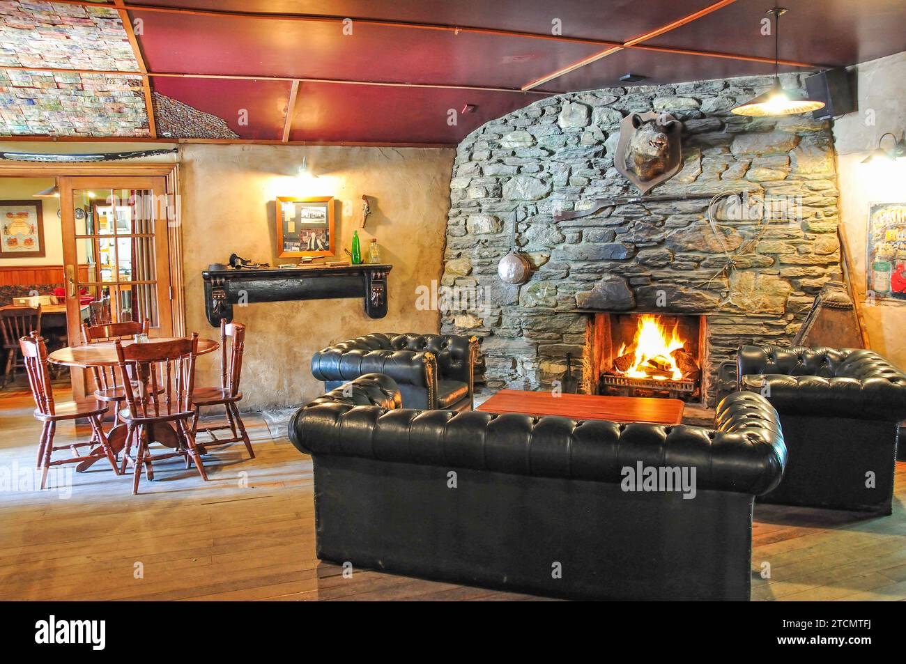 Interior room with log fire in historic Cardrona Hotel, Cardrona, Otago ...