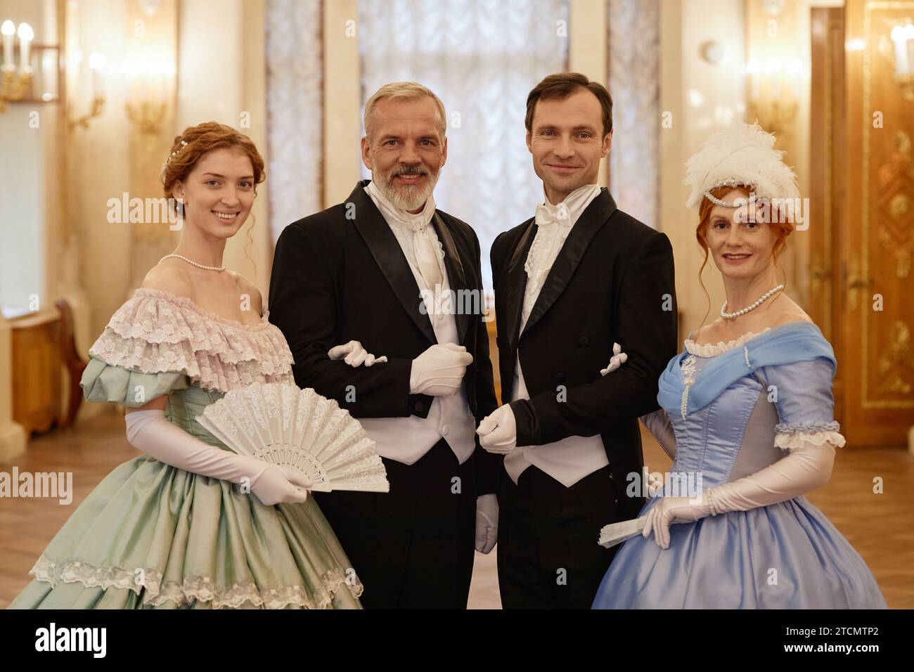 Diverse group of people wearing historic costumes looking at camera ...
