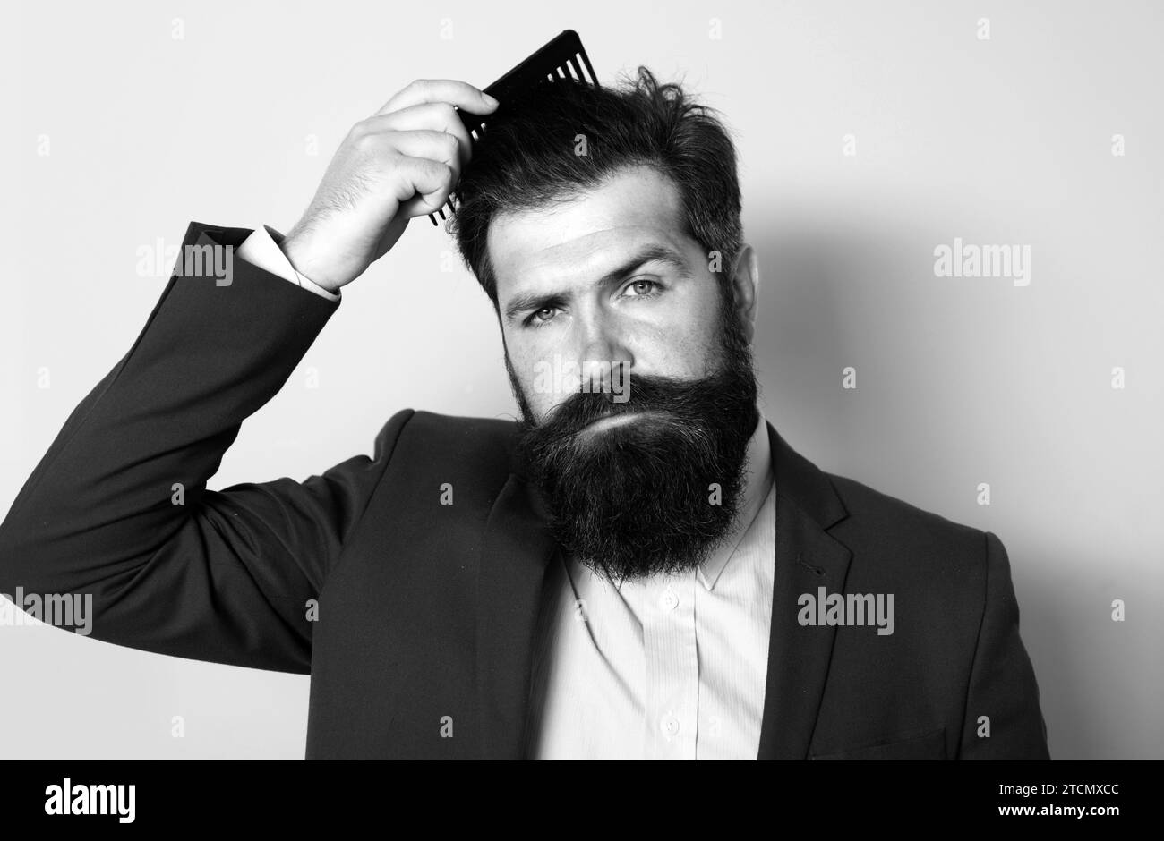 Man hairstyle, modern haircut. Man styling his hair with a comb ...