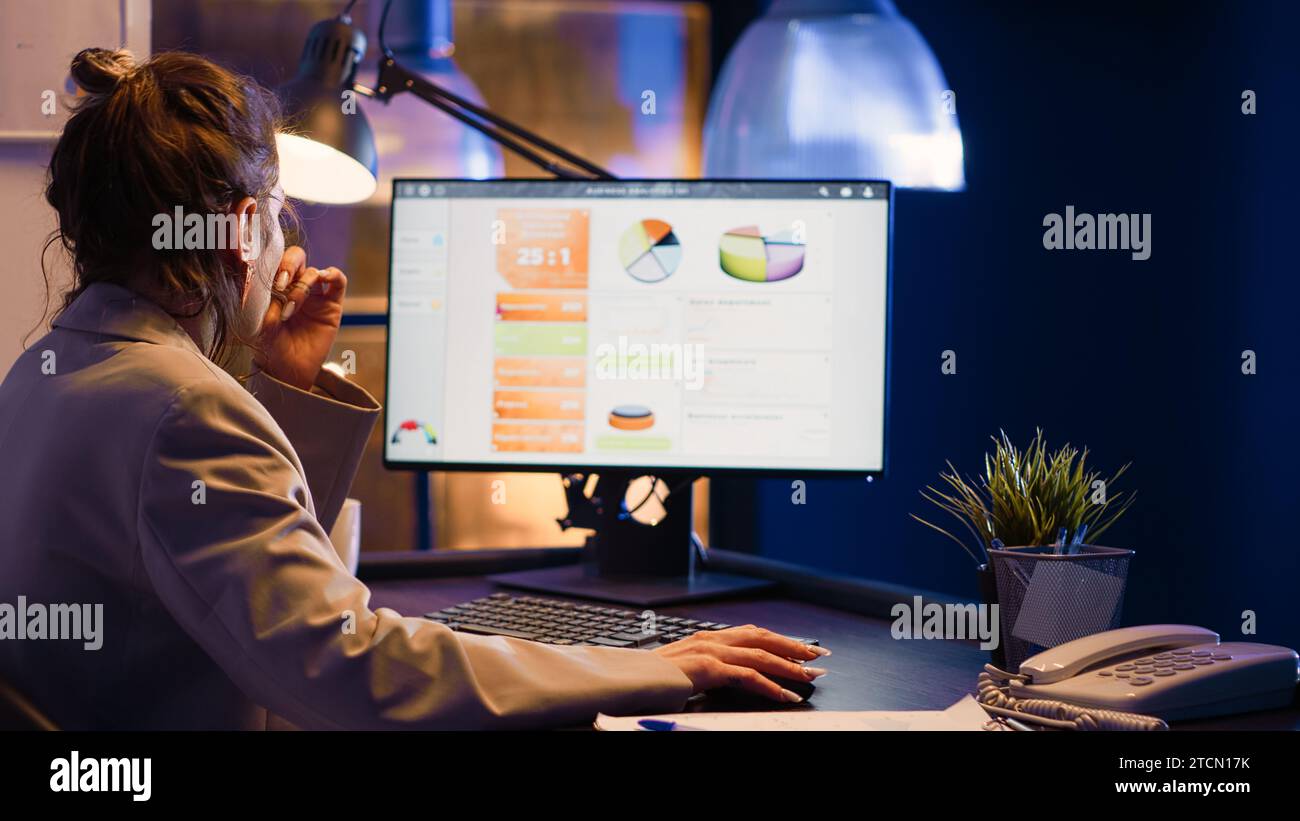 Office worker looking at computer running diagrams on screen, planning ...