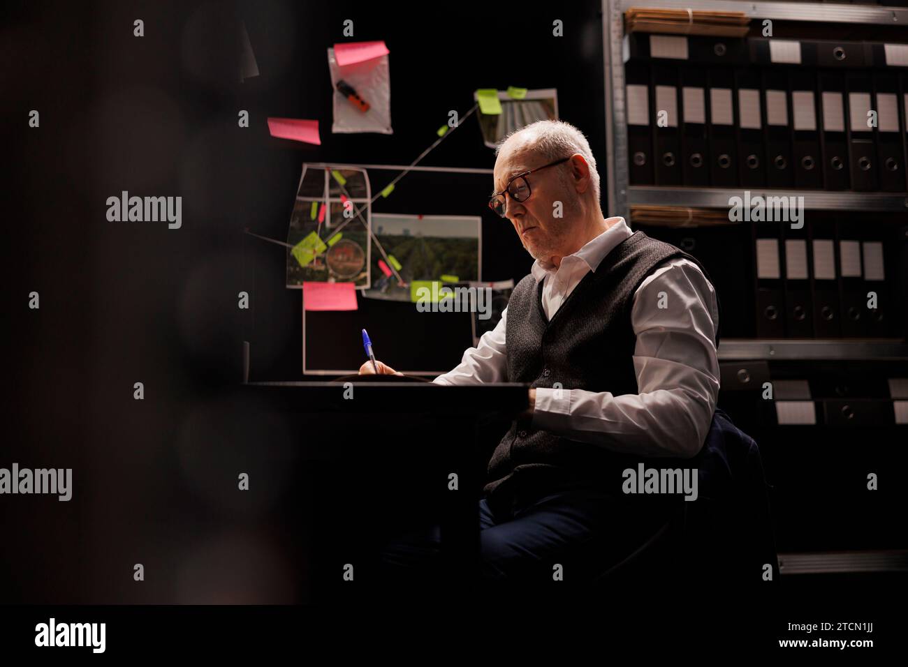 Overworked senior private investigator in formal suit, working ...