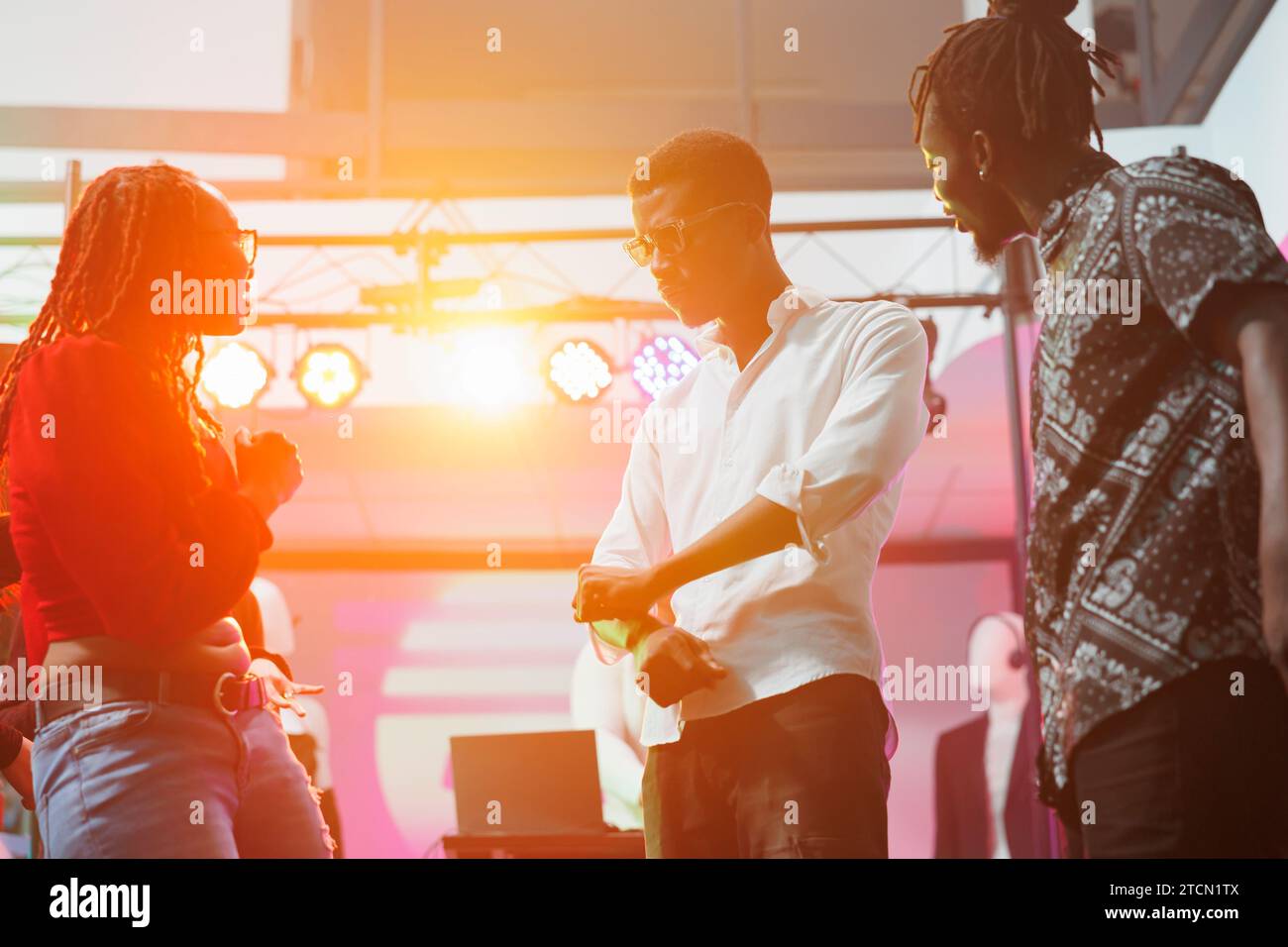 Young couple socializing and dancing in nightclub illuminated with ...