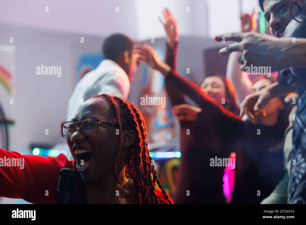 Woman singing in microphone loudly and screaming while partying with ...