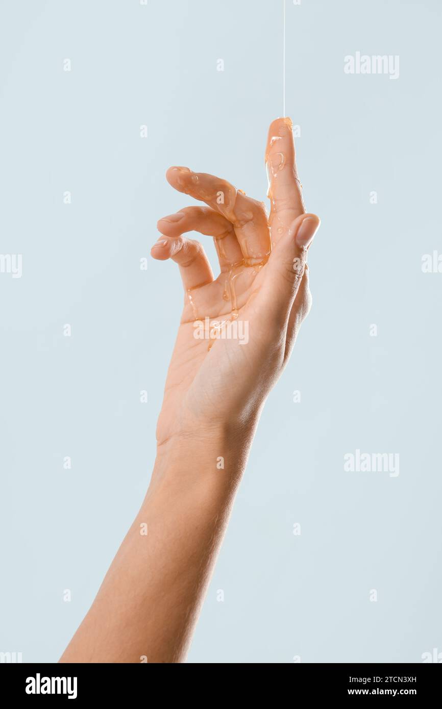 Woman with dripping honey on her hand against light background Stock ...