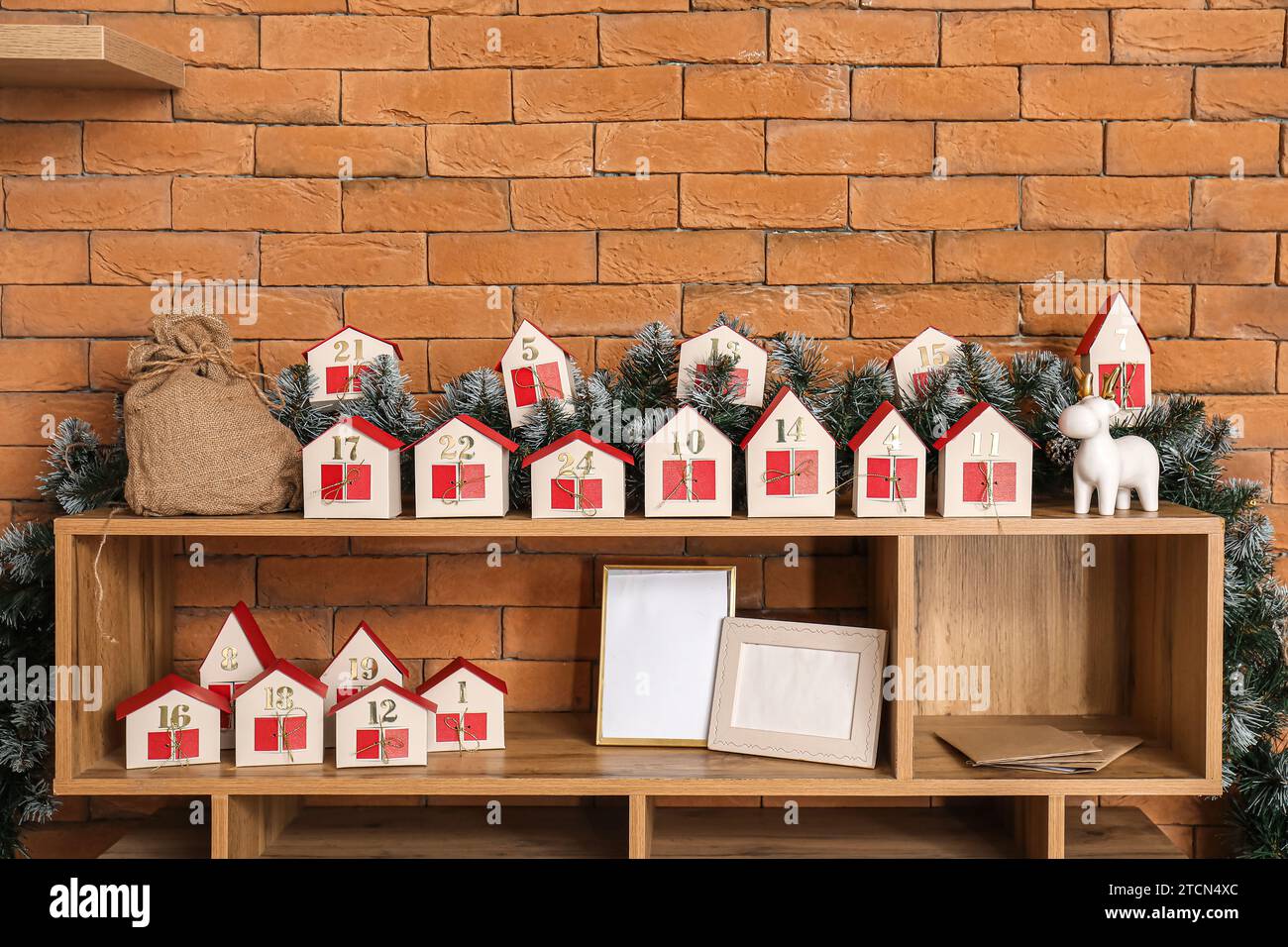Shelf unit with Christmas advent calendar and photo frames in room ...