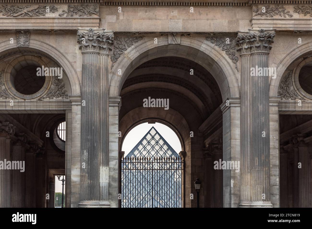 Louvre Museum Pyramid seen through arch of building Stock Photo - Alamy