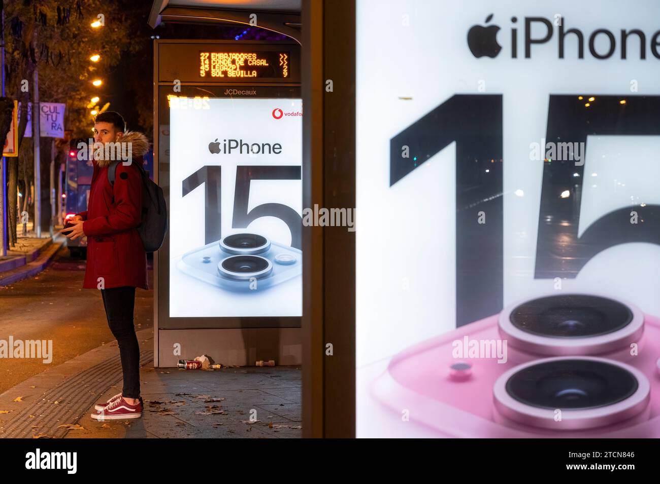 A commuter waits at a bus stop next to an American multinational ...