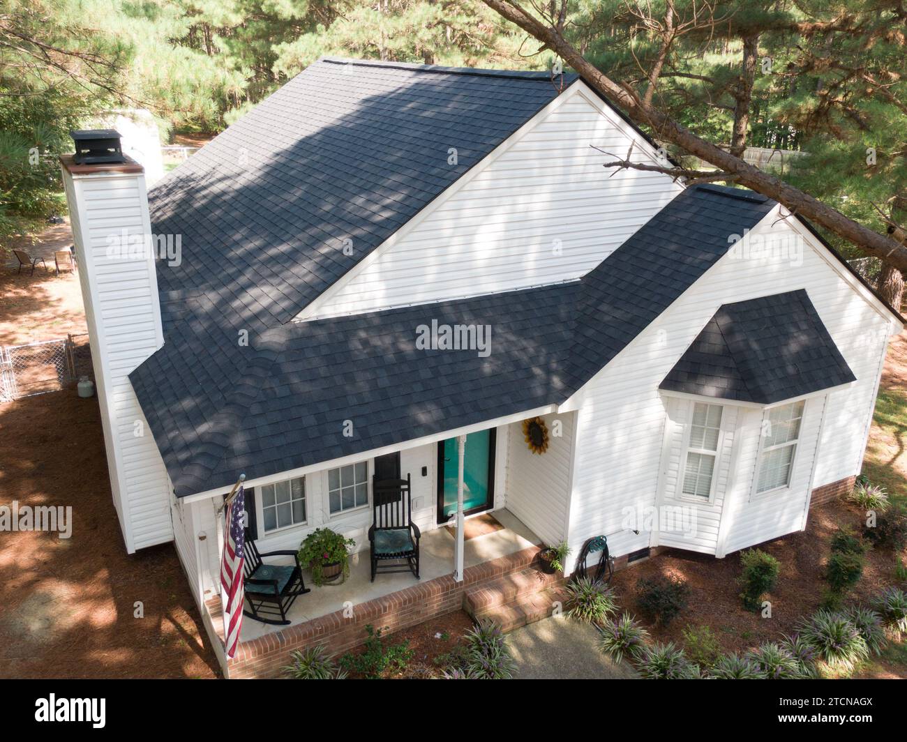 drone photos of a new roof after installation on a wooded lot with lots ...