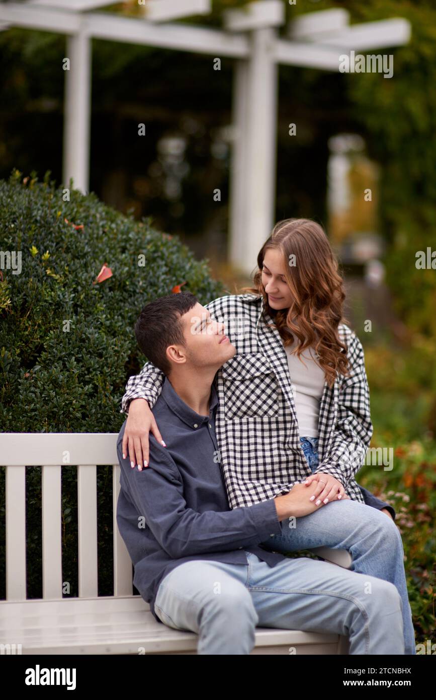 Autumn Romance: Young Couple Embracing and Kissing on Park Bench. Young ...