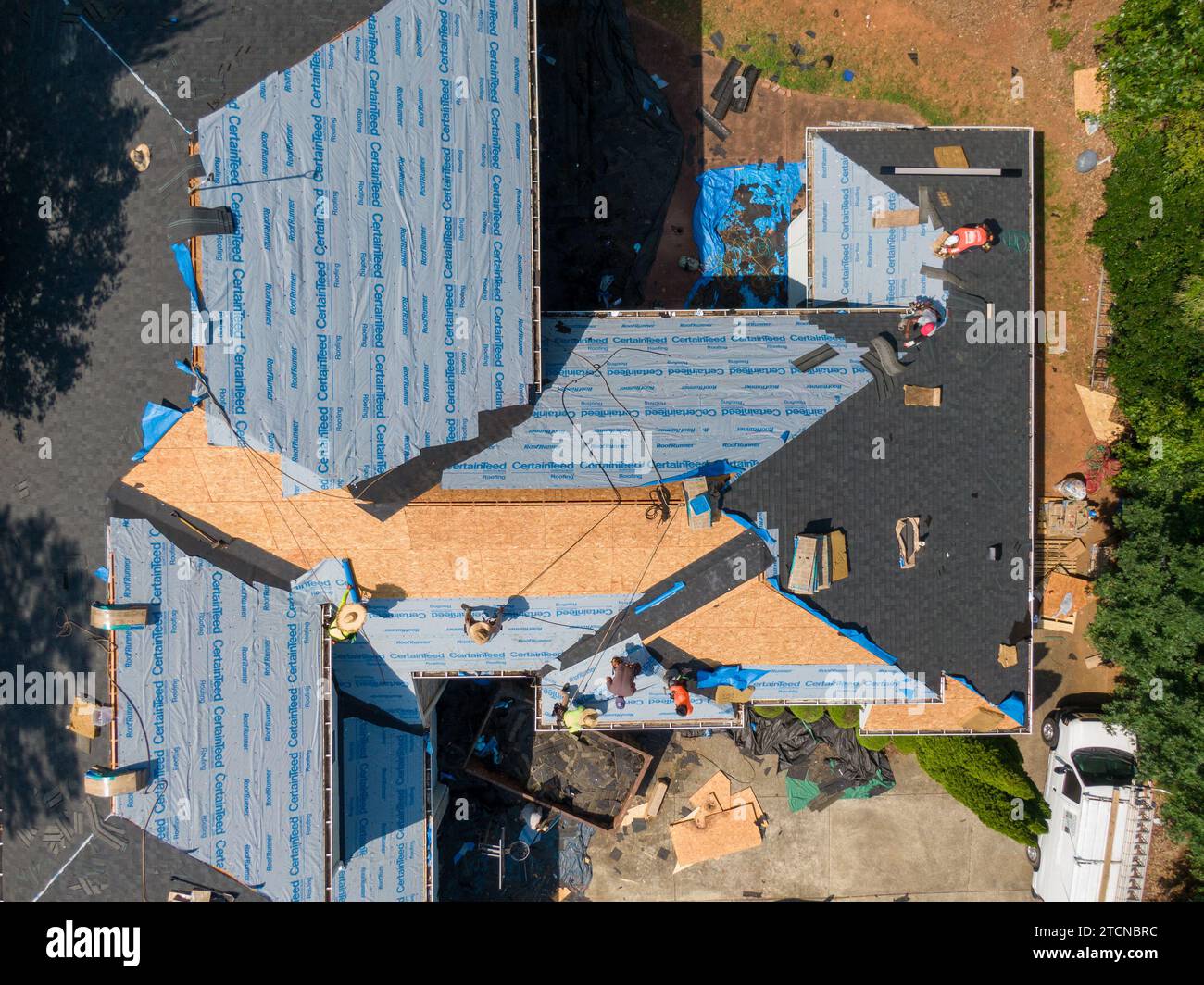 drone images during a large residential roof installation on a bright ...