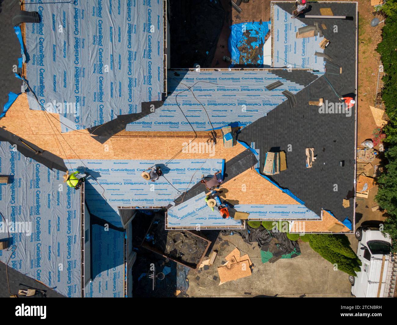 drone images during a large residential roof installation on a bright ...