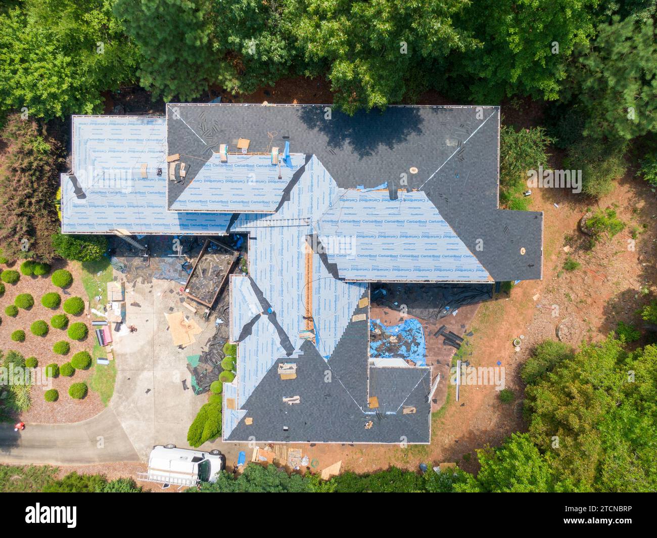 drone images during a large residential roof installation on a bright ...