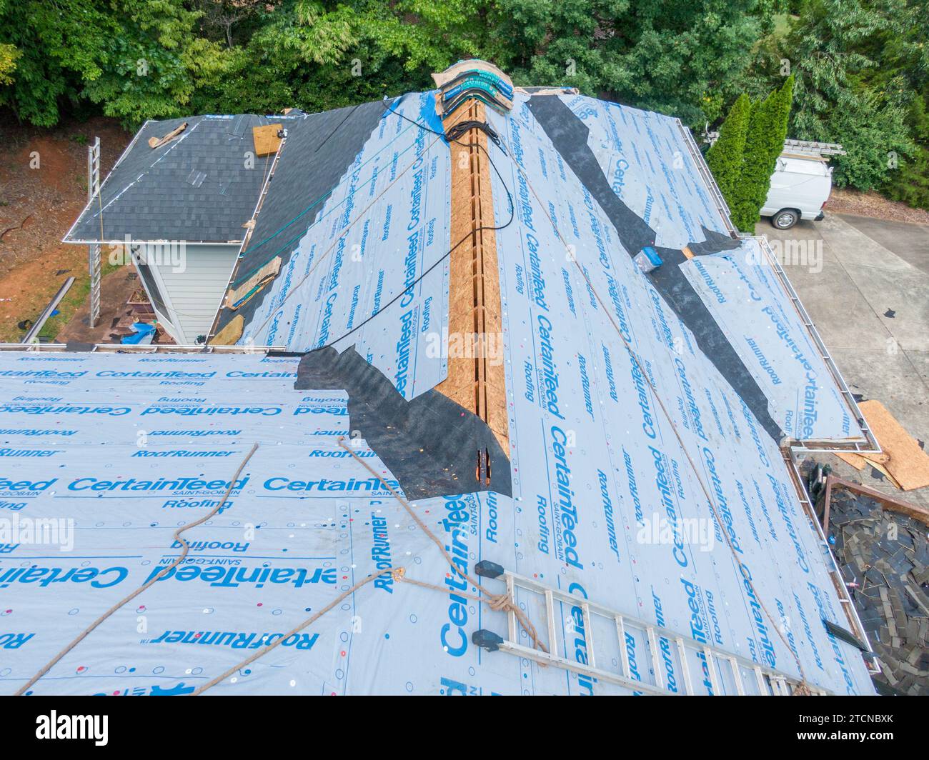 drone images during a large residential roof installation on a bright ...