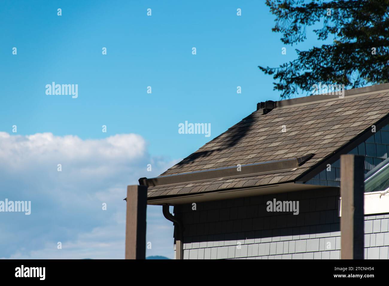 Image of a house roof and blue sky. North American rural landscape ...