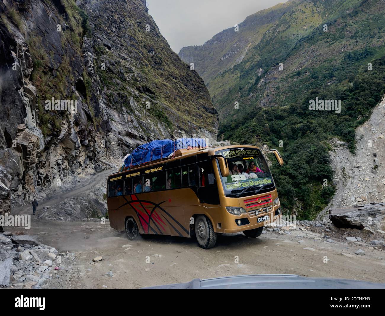 A bus navigates the challenging dirt road in the Kali Gandaki Gorge ...