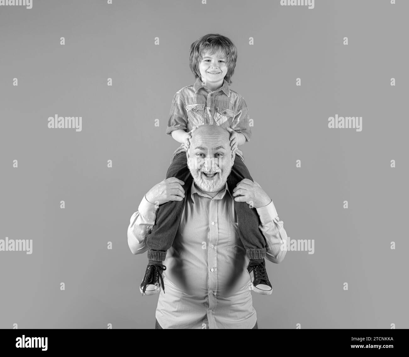 Young grandson and old grandfather piggyback with funny face isolated ...