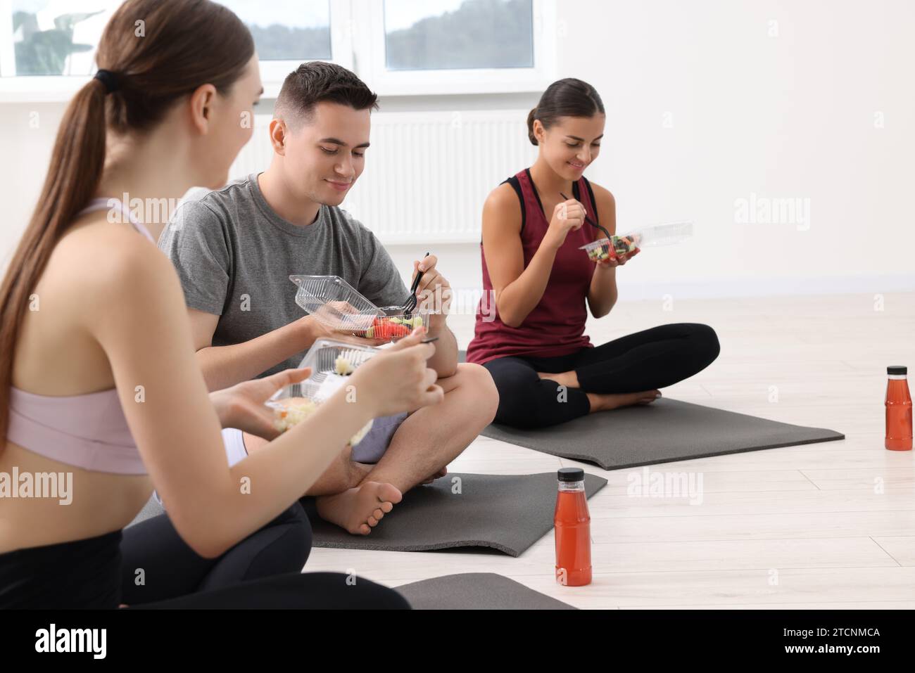 Group of people eating healthy food after yoga class indoors Stock ...