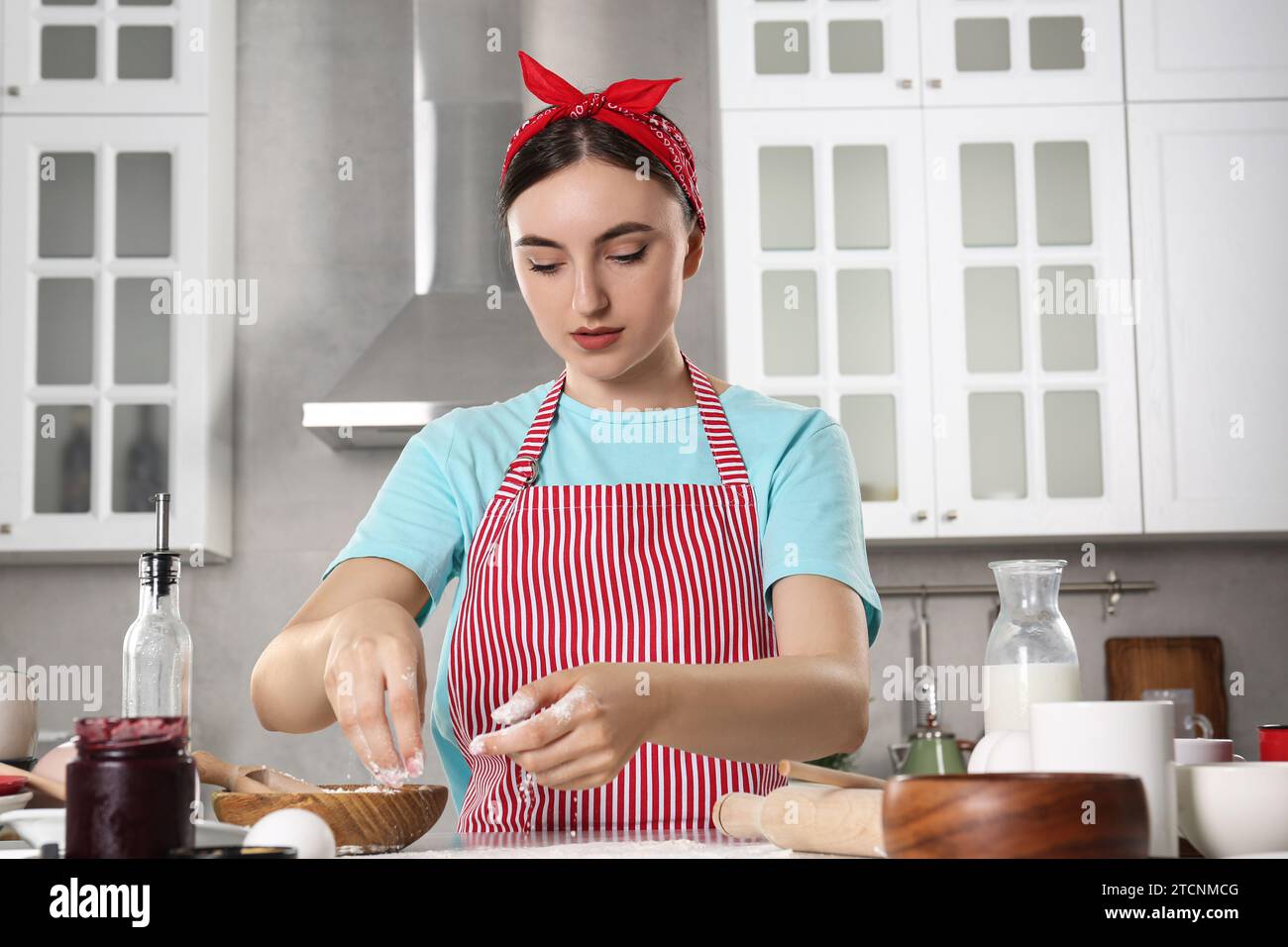 Beautiful woman cooking in kitchen. Dirty dishware, food leftovers and ...
