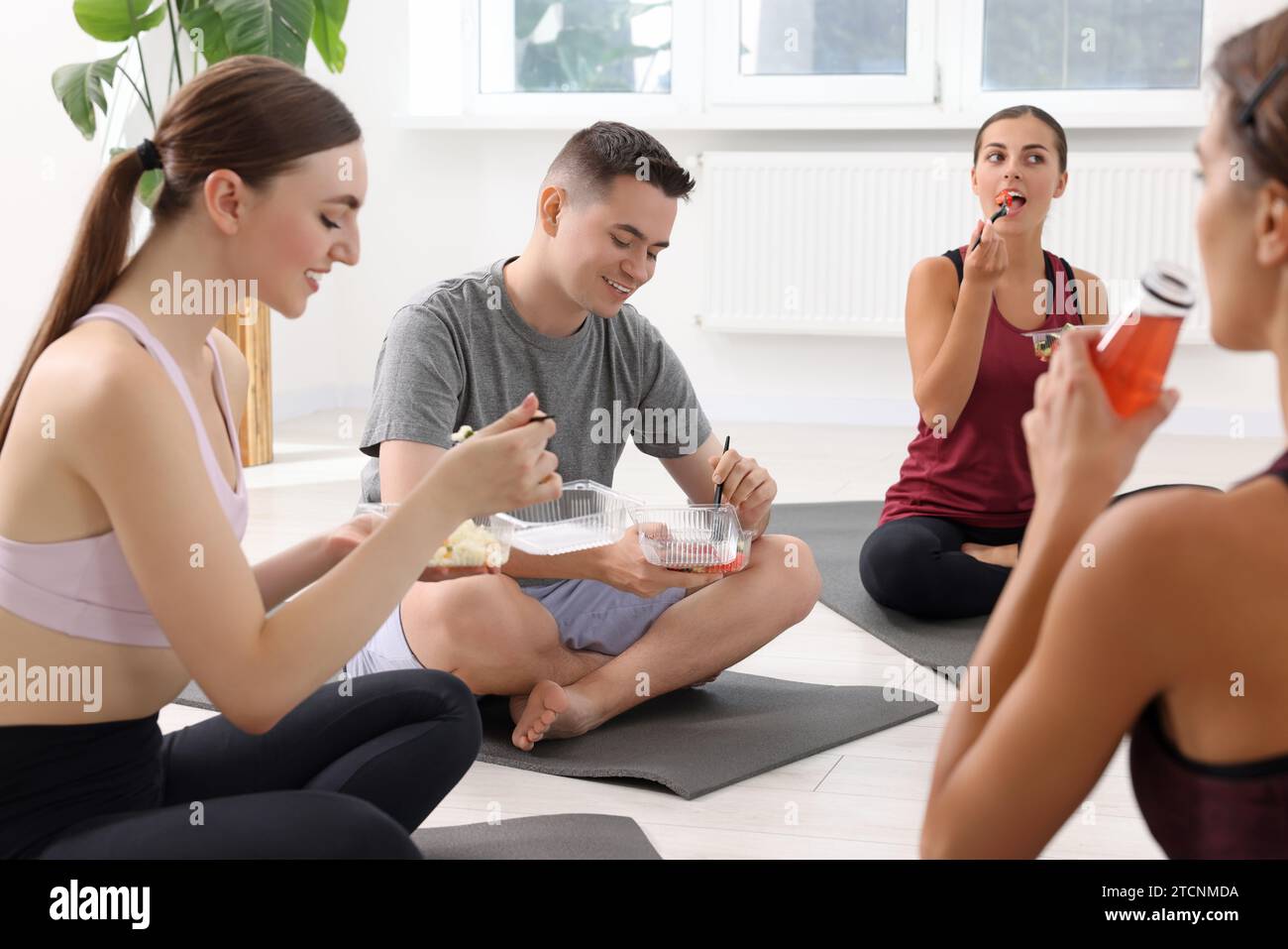 Group of people eating healthy food after yoga class indoors Stock ...