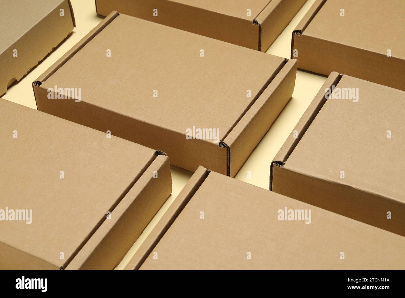 Many closed cardboard boxes on pale yellow background, closeup Stock ...