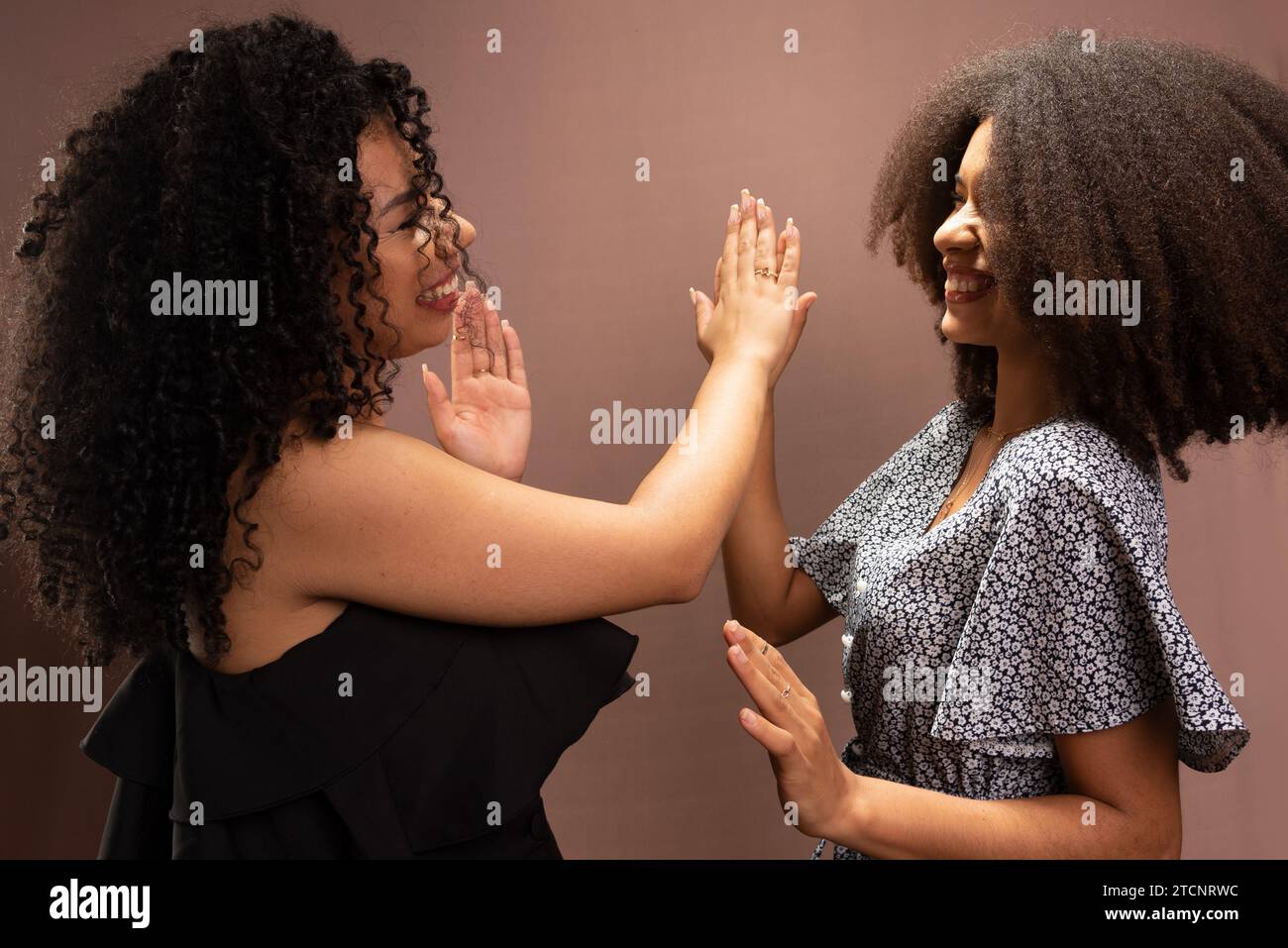 Two young, happy friends touching each other's hands. Friendship ...