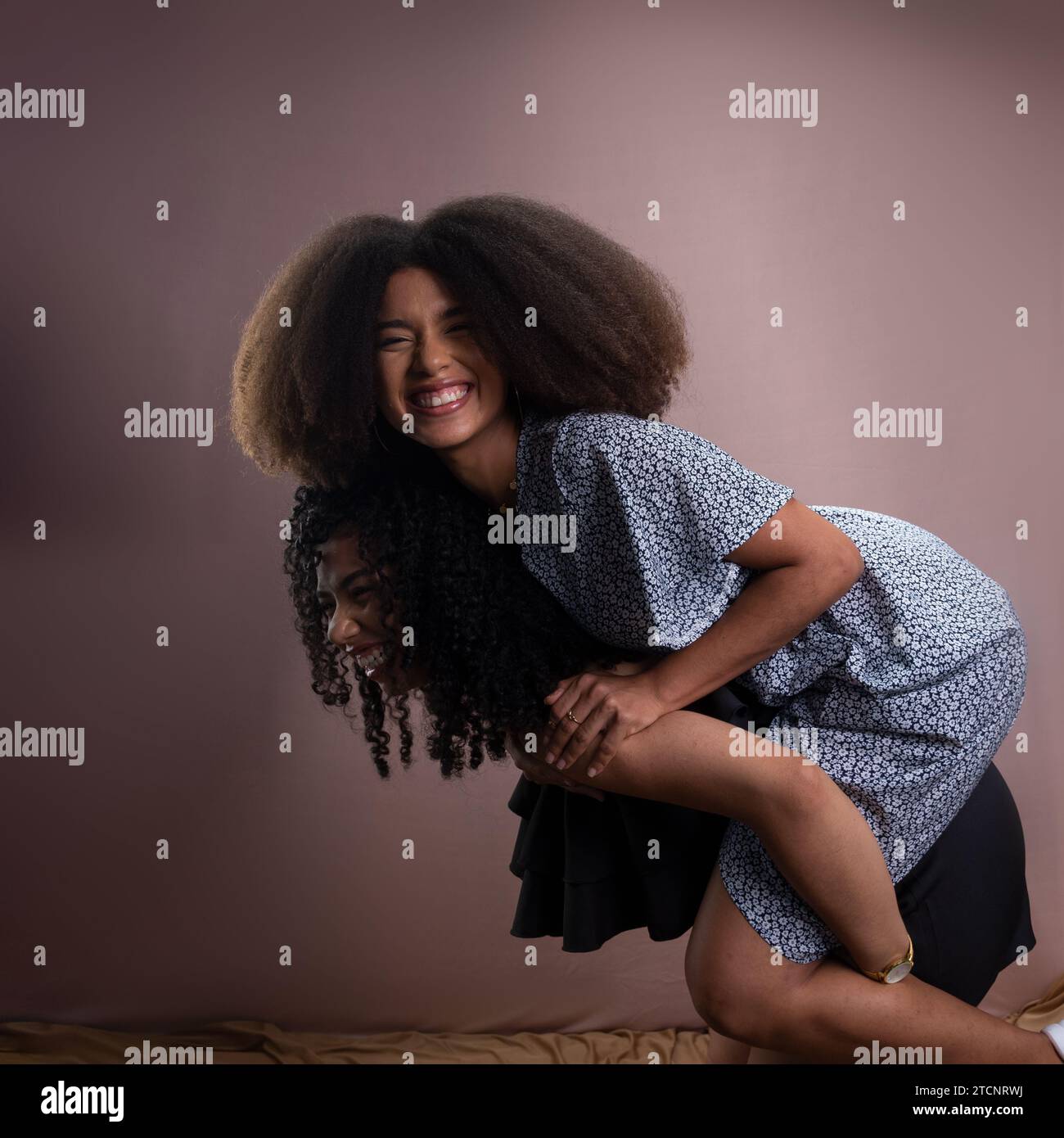 Two young, happy, beautiful friends. One carries the other on its back ...