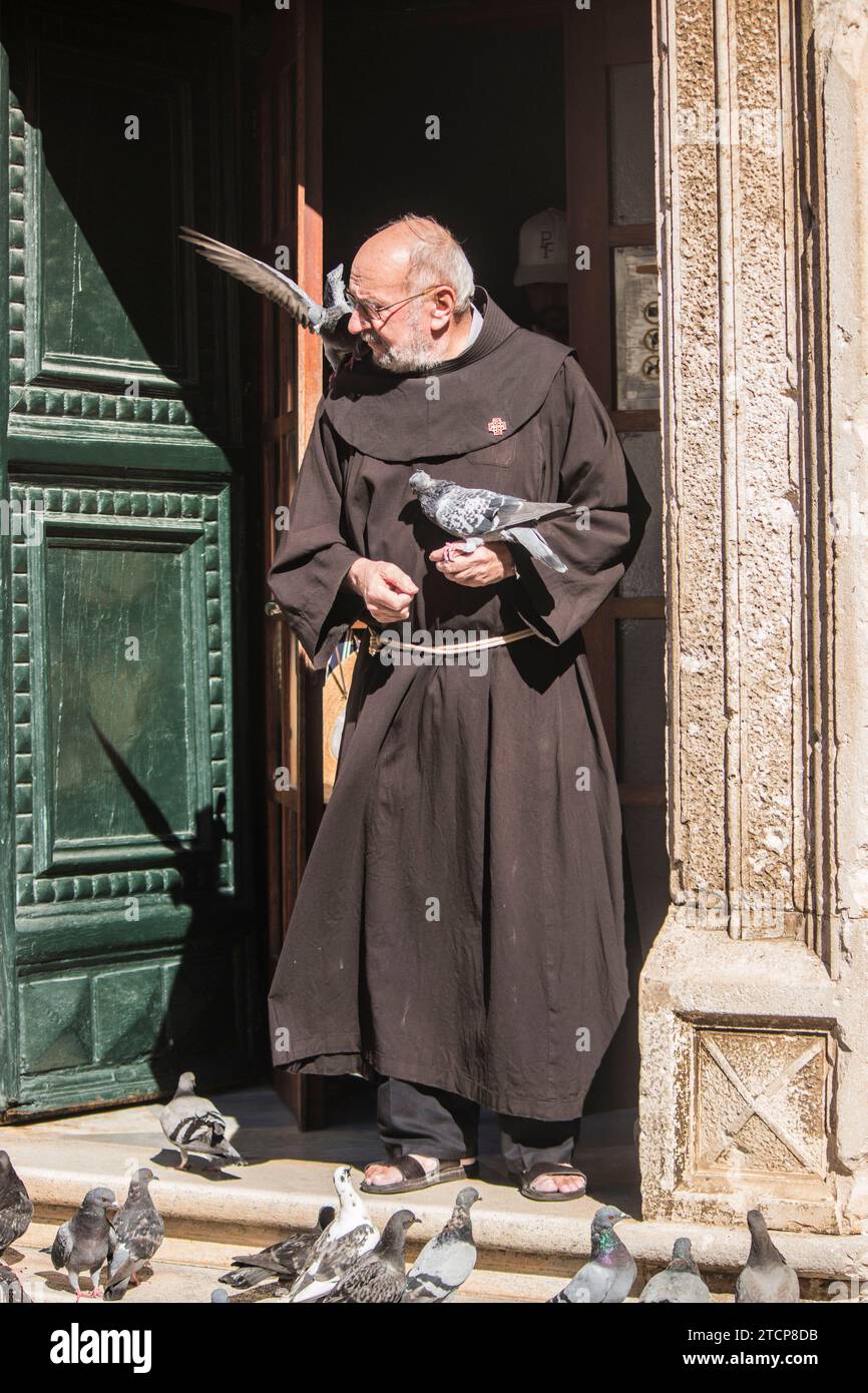 Monk in Dubrovnik feeding the pigeons near the Pile gate Stock Photo ...