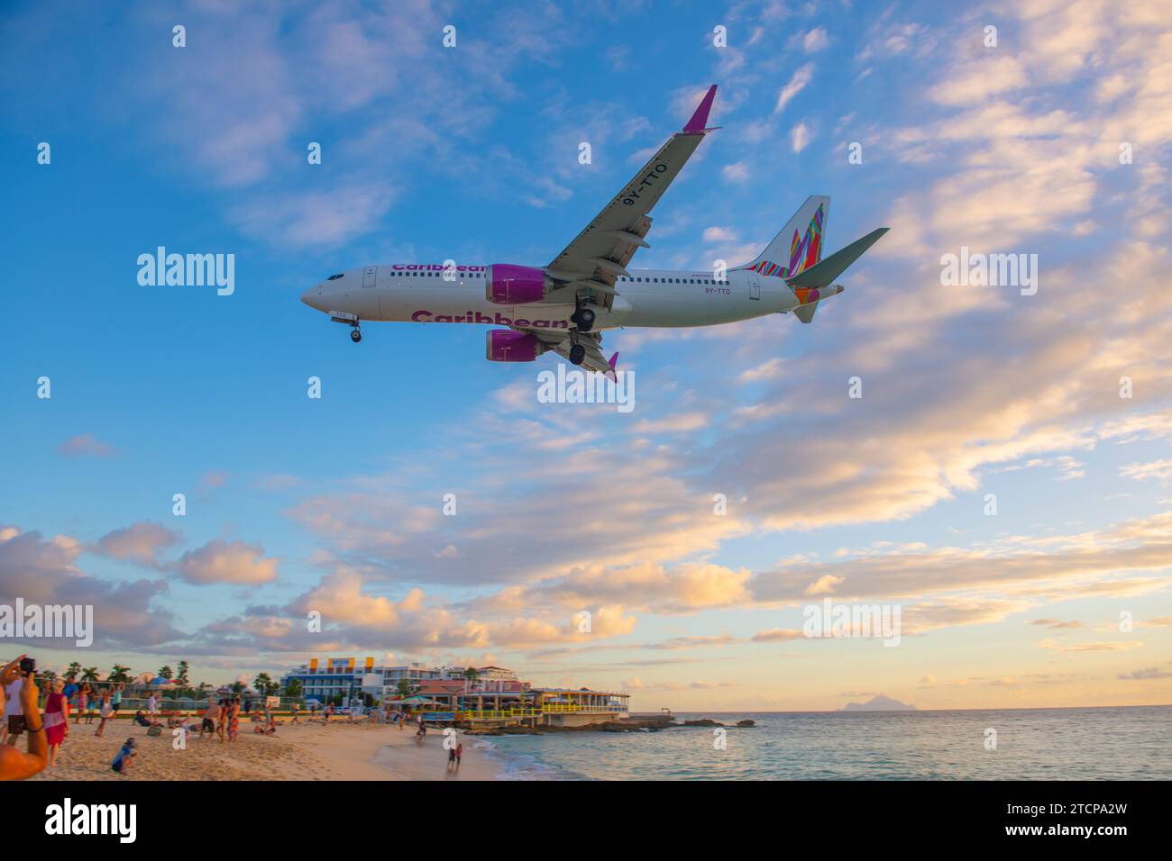Caribbean Airlines Boeing 737 Max 8 flying over Maho Beach at sunset ...