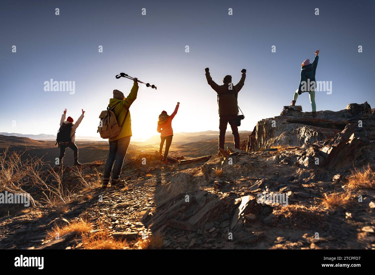 Big group of young hikers with backpacks are standing with open arms in ...
