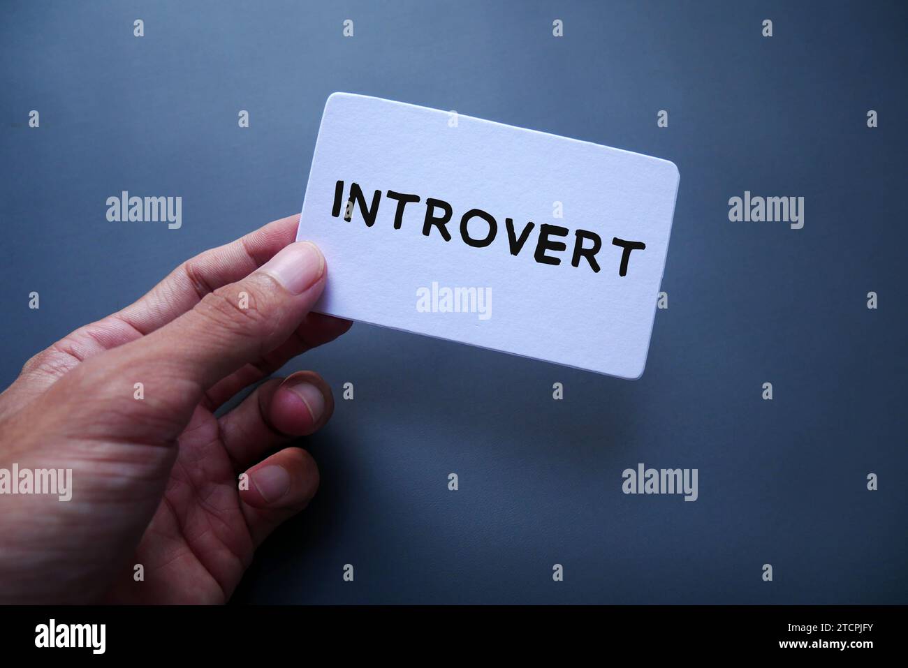 Hand holding a card with text World Introvert Day. January 2. Vacation ...