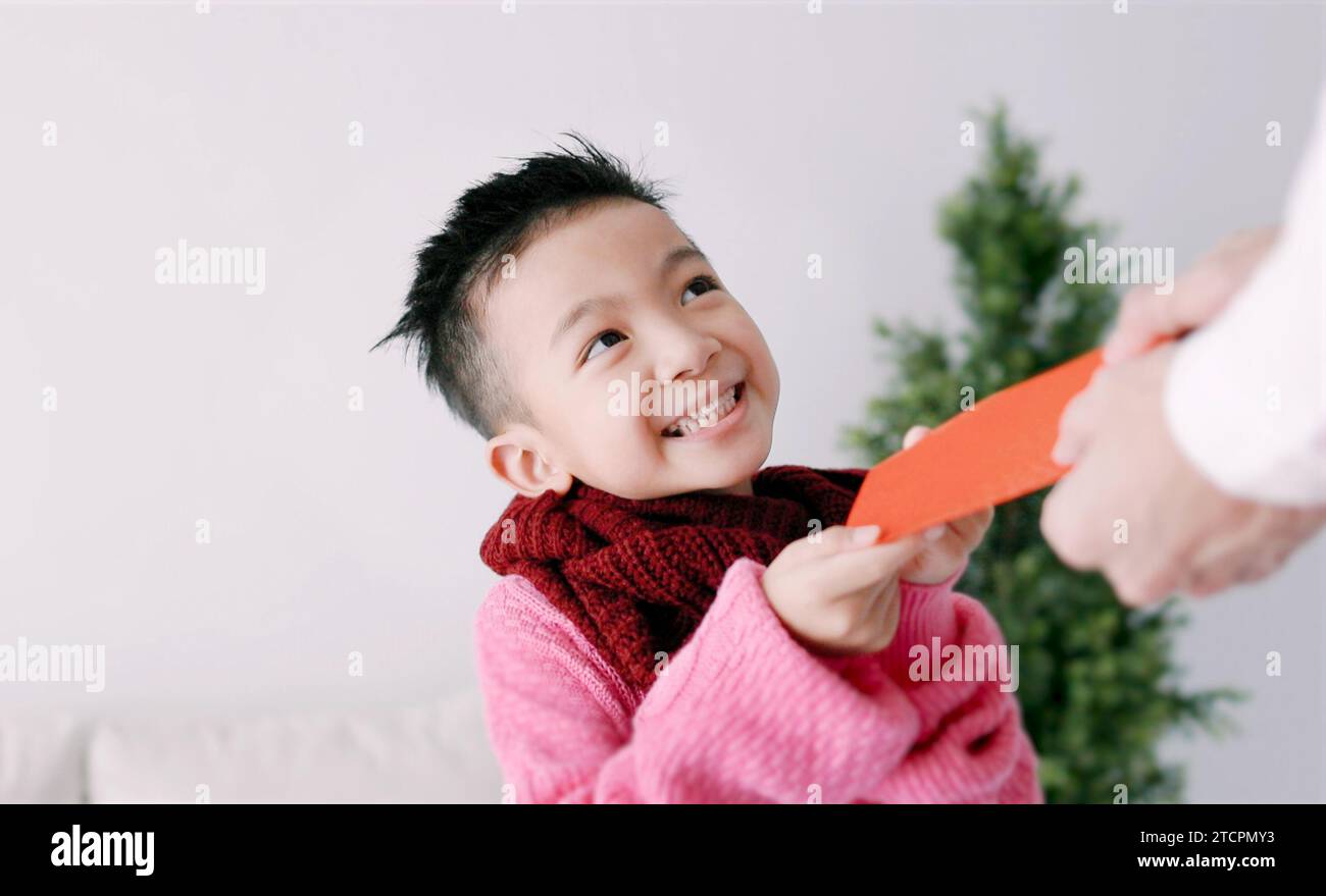 happy asian little boy receiving red envelope and celebrating chinese ...