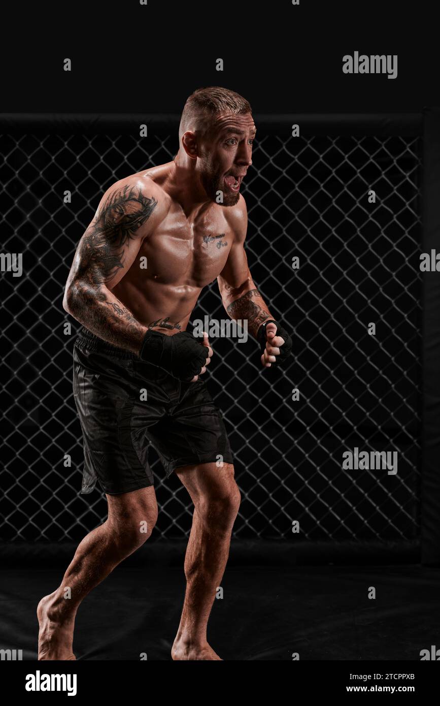 Conceptual image of a kickboxer. A real fighter stands in the real cage ...